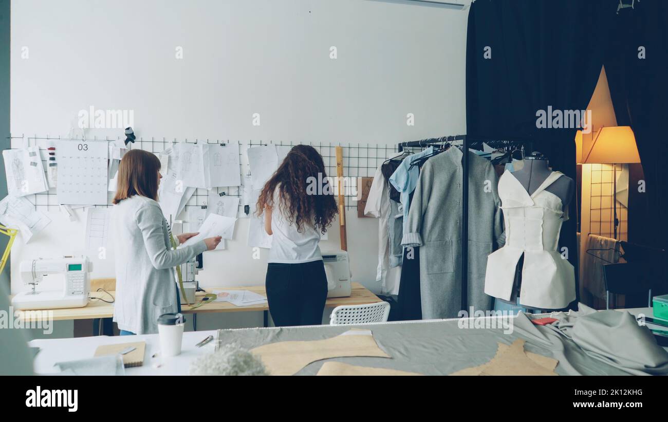 Young female entrepreneurs clothing designers standing in front of wall ...