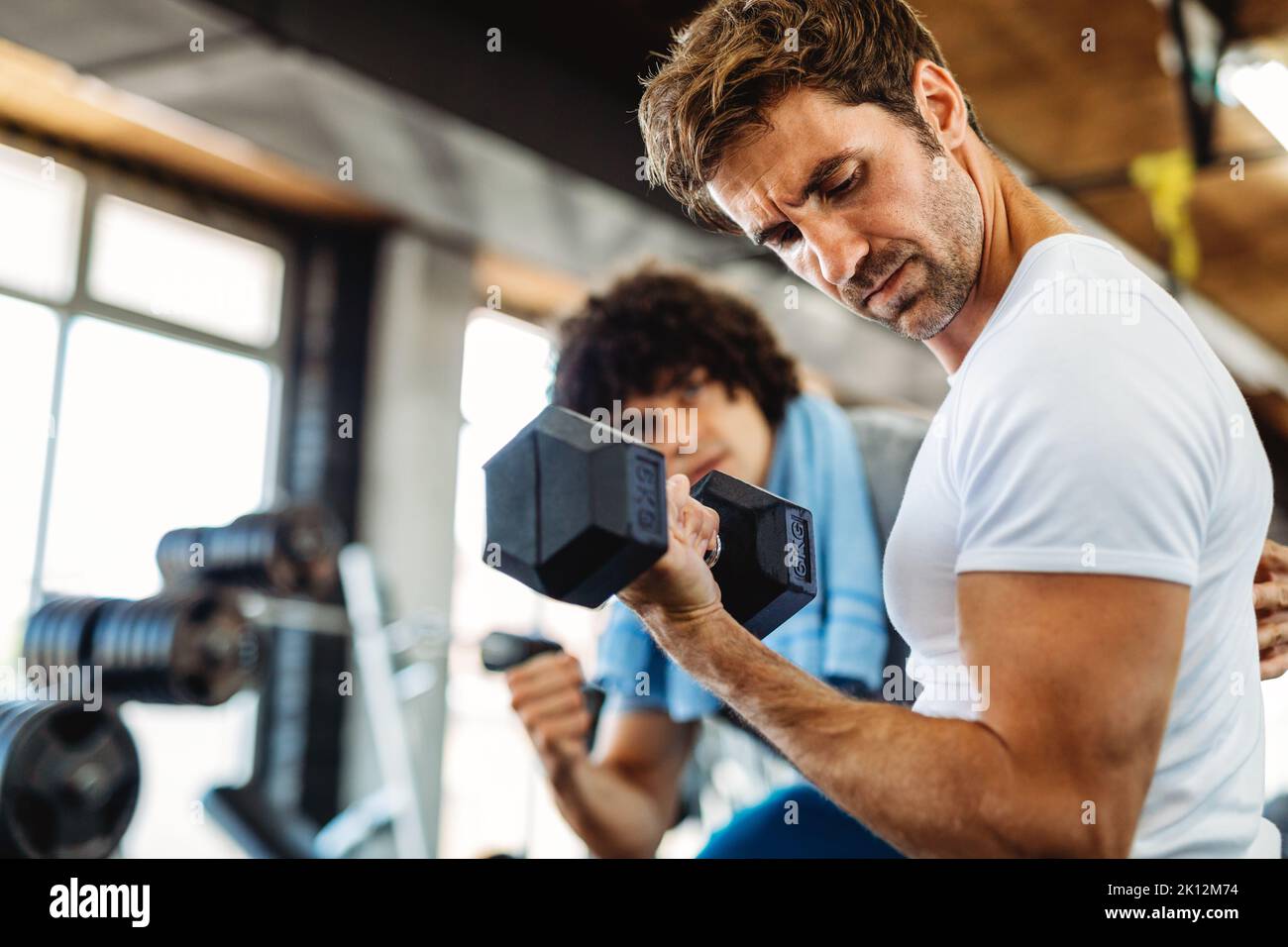 Fit man working out in gym with personal trainer to stay healthy. Sport ...