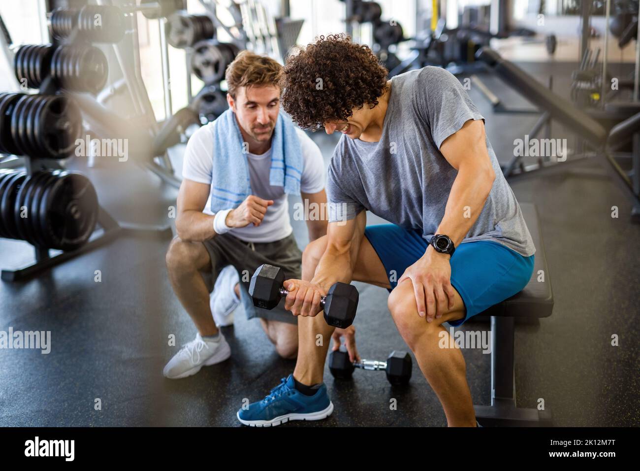 Fit man working out in gym with personal trainer to stay healthy. Sport ...