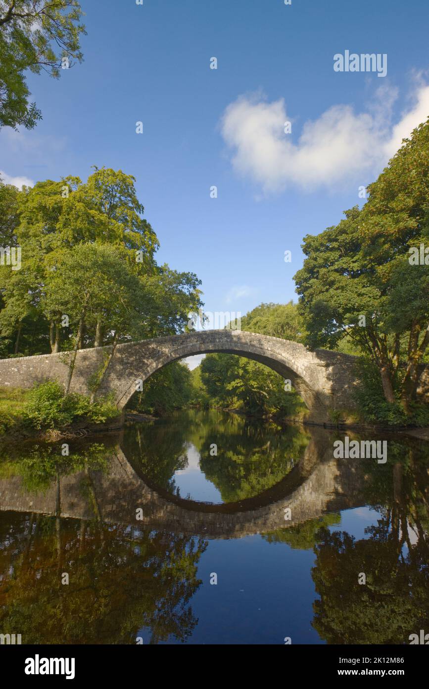 The 16th century Ivelet Bridge and its reflection in the River Swale ...