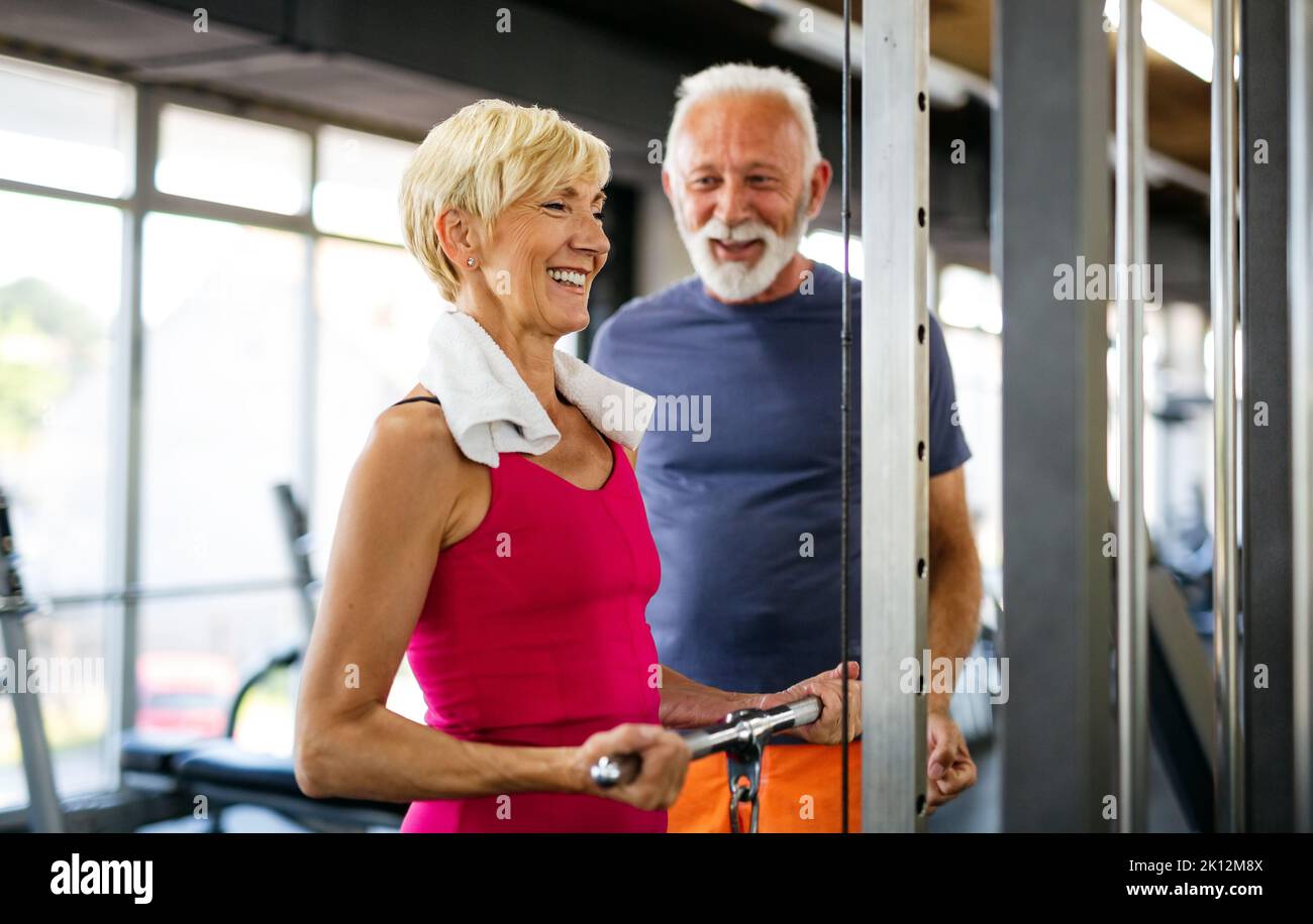 Senior fit man and woman doing exercises in gym to stay healthy Stock ... Senior fit man and woman doing exercises in gym to stay healthy Stock ...
