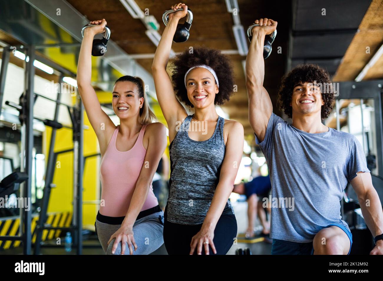 Group of fit people lifting dumbbells during an exercise class at the ...