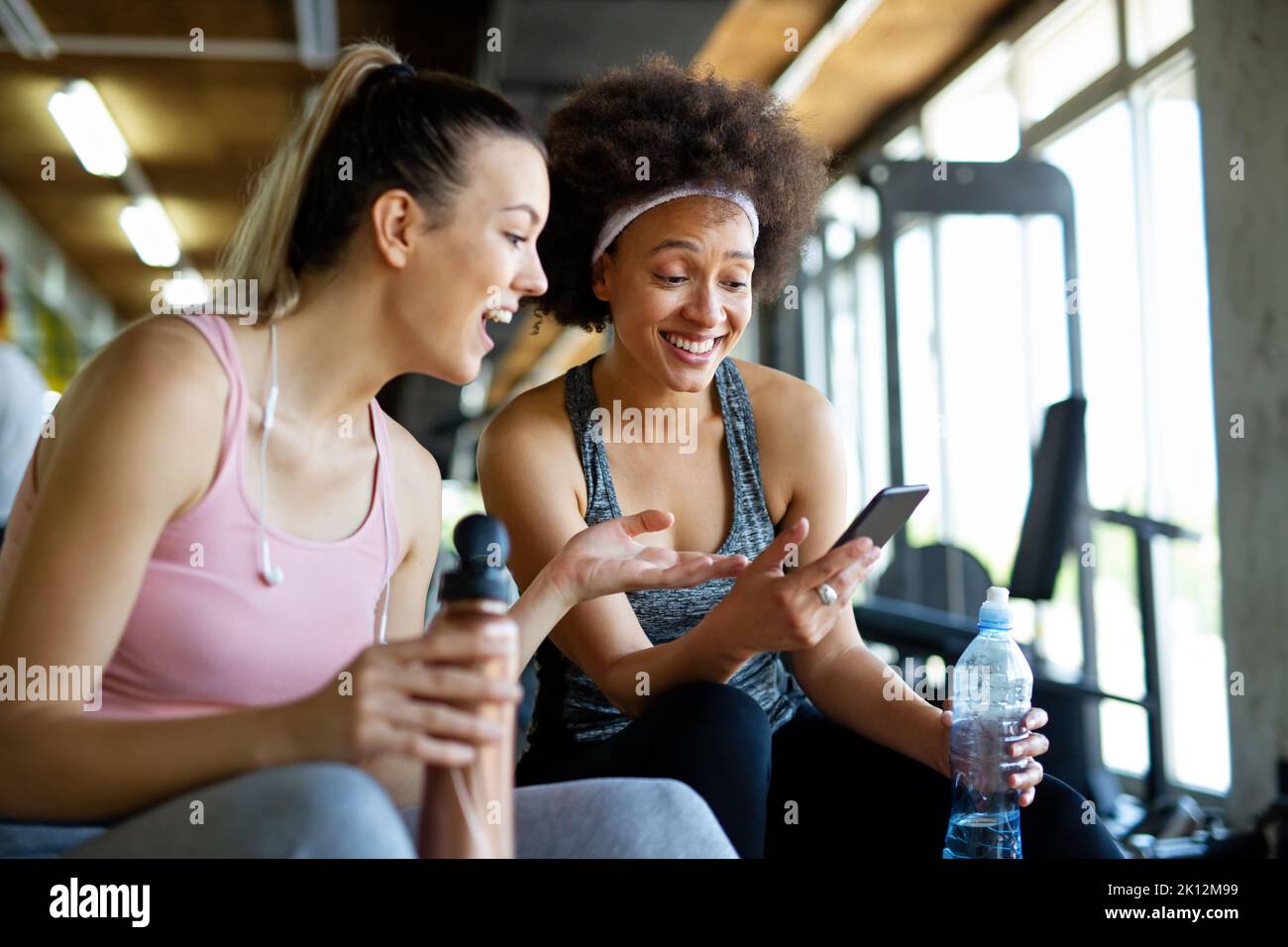 Happy fit women, friends smiling, talking and taking photos after work ...