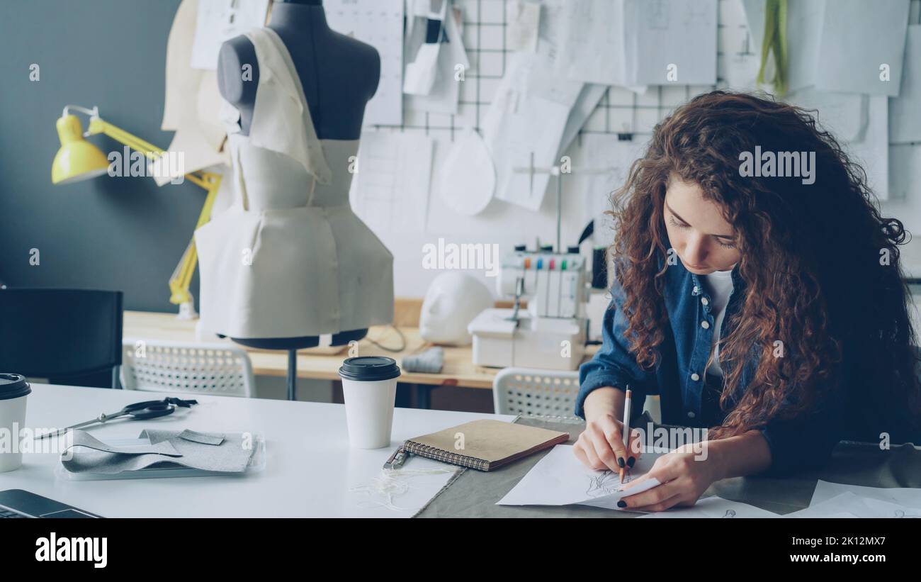 Young female artist fashion designer is drawing women's garment sketch ...