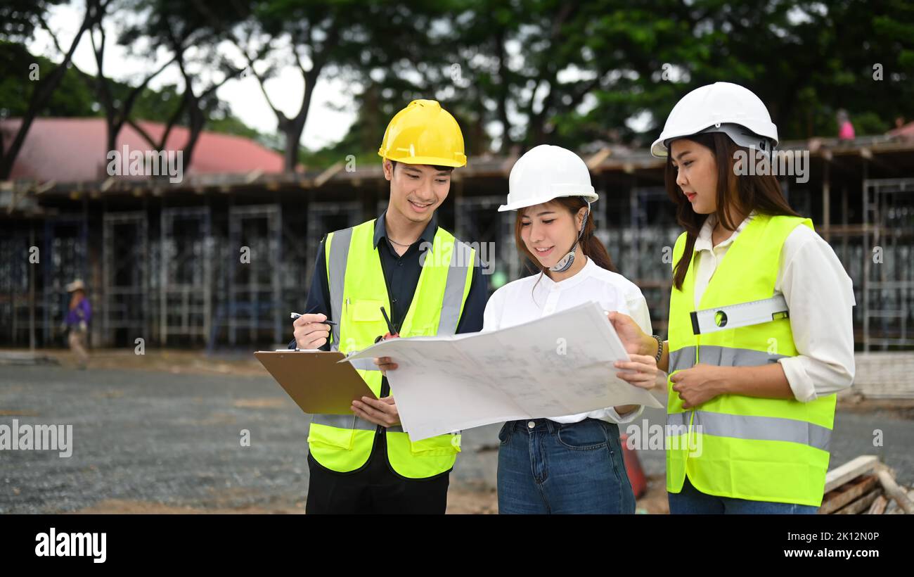 Architect and engineer in safety helmet and reflective jackets are ...