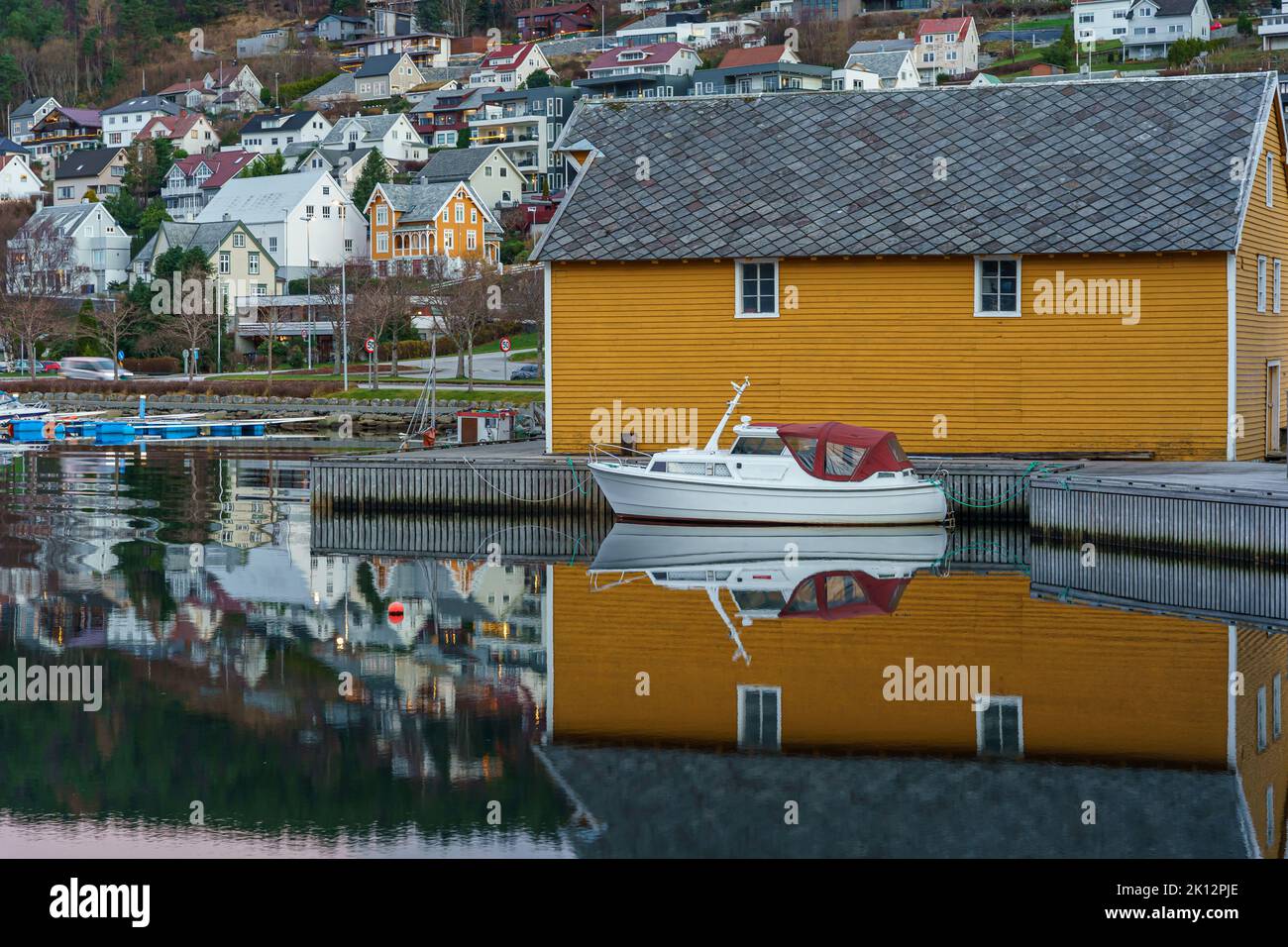 Reflection of a small boat and yellow seahouse at sea Stock Photo - Alamy
