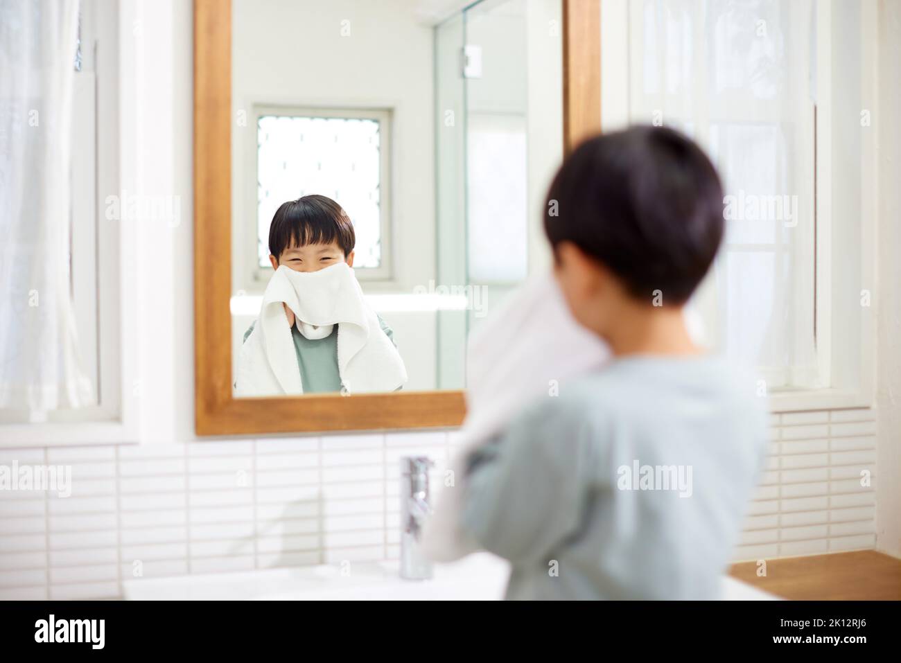 Japanese kid wiping face with towel at home Stock Photo - Alamy