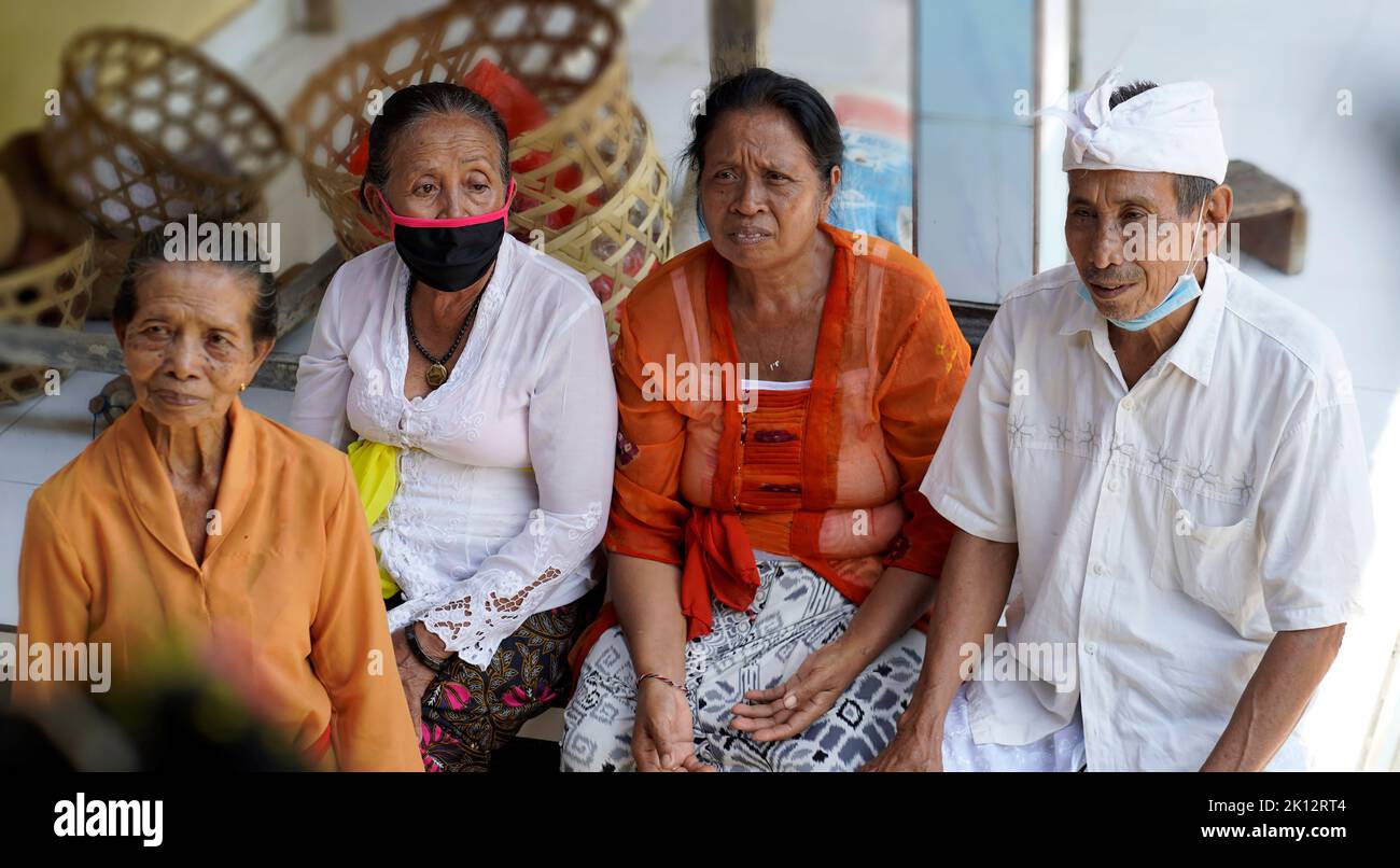Four senior Balinese women and a man in traditional clothes sitting ...