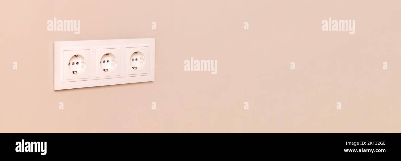 Group of white european electrical outlets on modern neutral beige wall ...