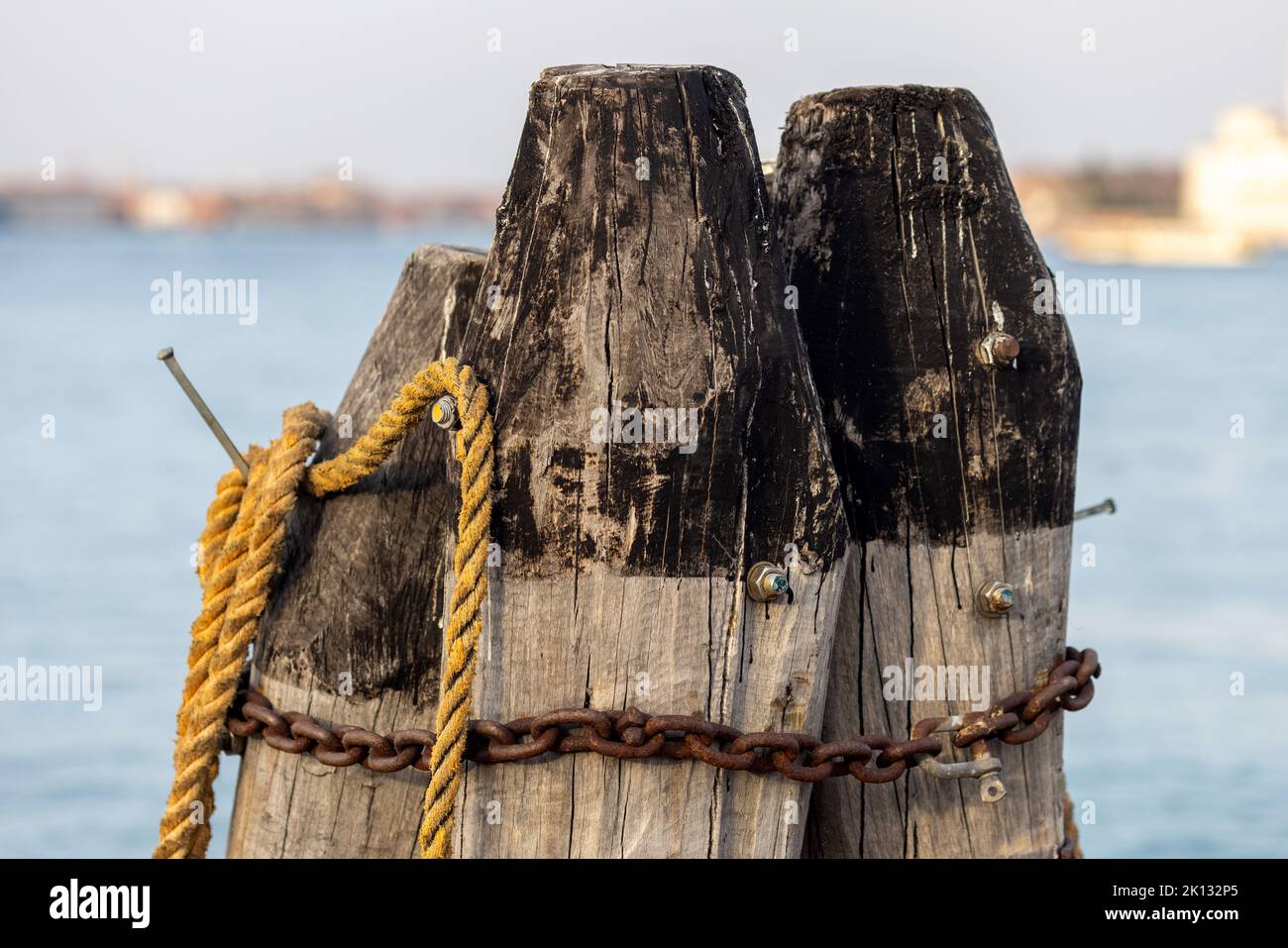 Wooden pillars with old rope and chain in sea at Venice dock. Large ...