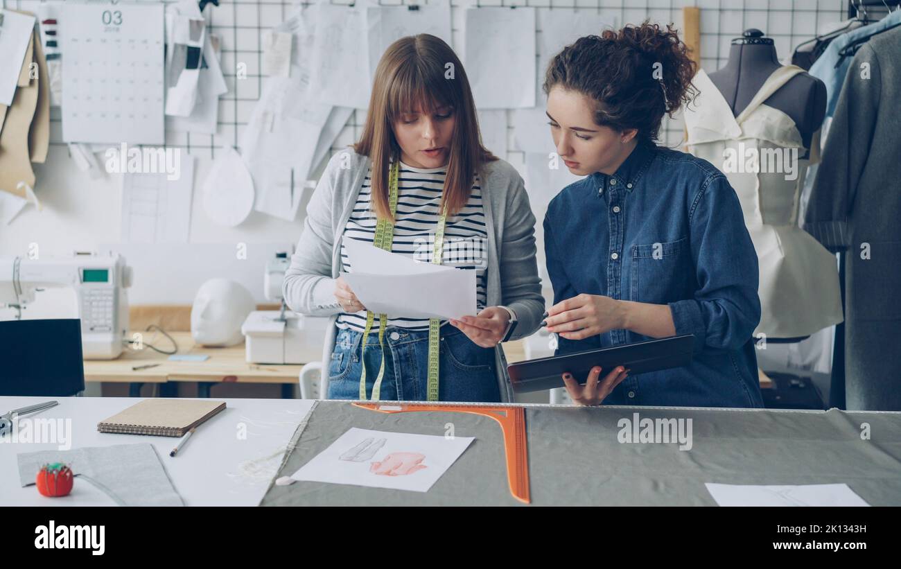 Creative clothing designers are looking at drawings and comparing them ...