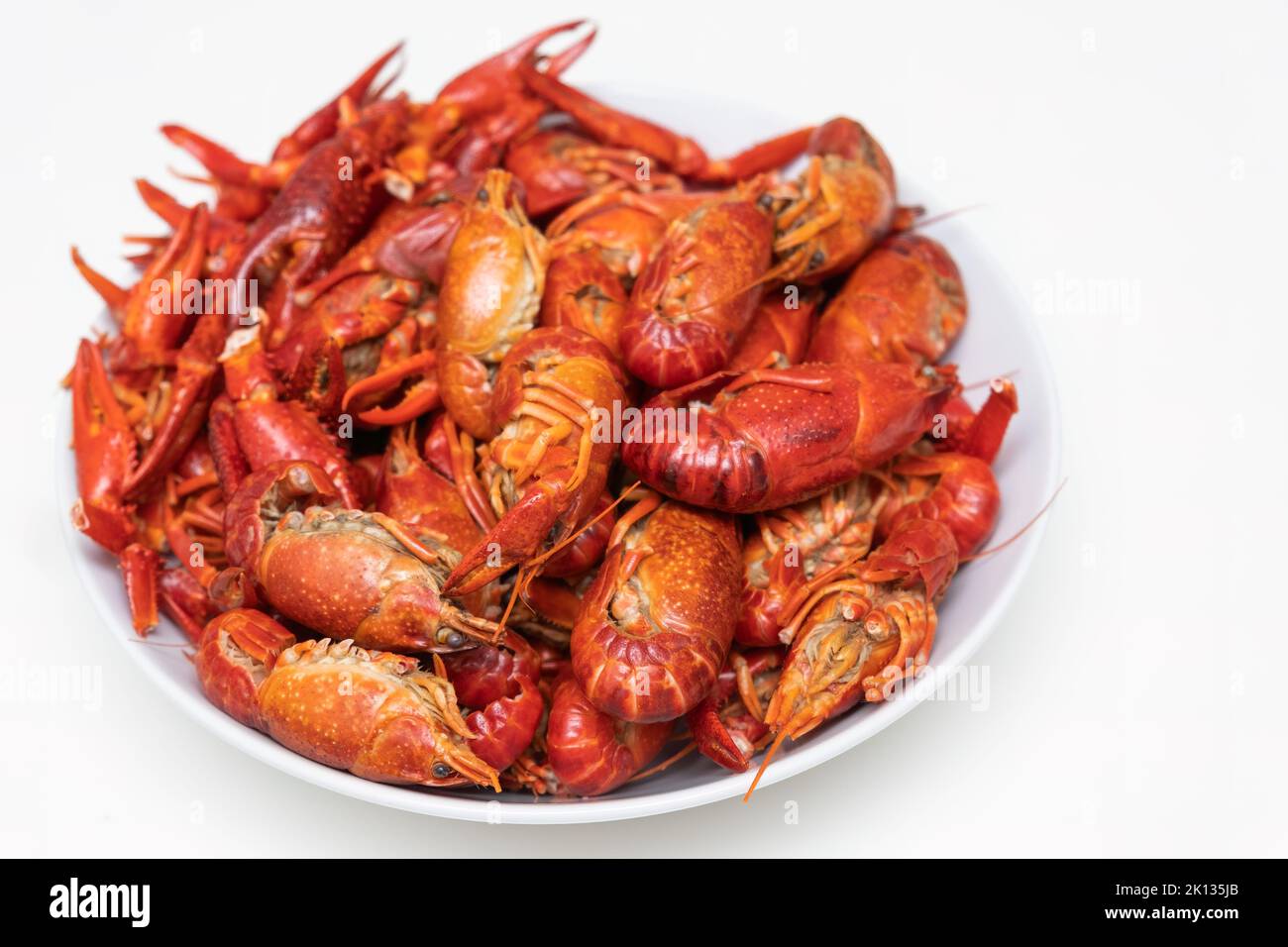 Red boiled crayfish with lemon on the plate isolated on a white ...