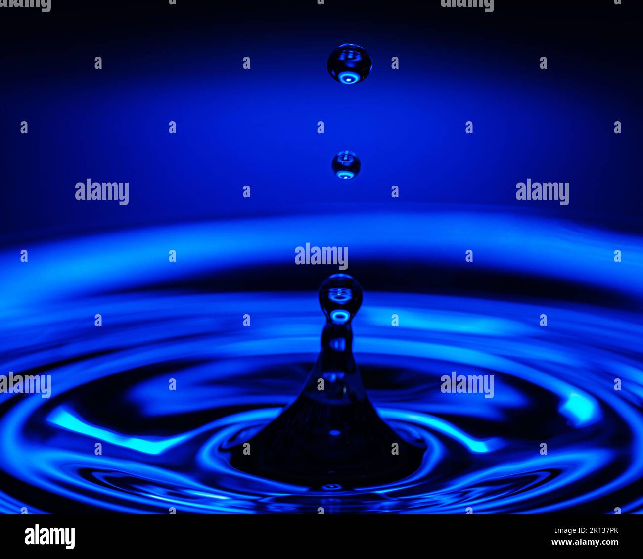 Macro water drop on a blue background and circles on it. Round water ...