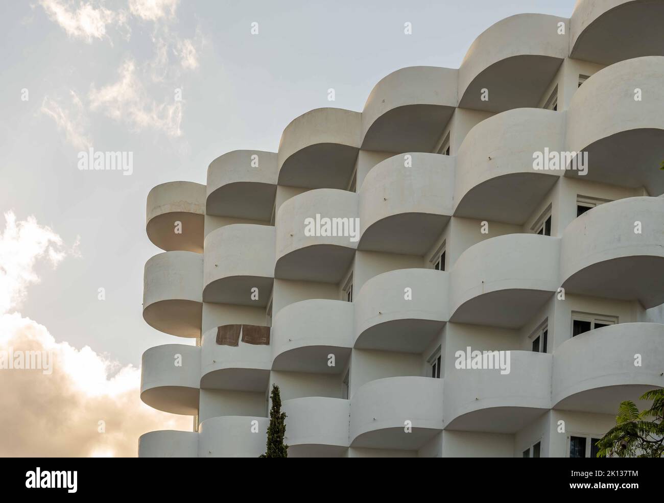 Facade with balconies of a white tourist hotel, with towels hanging ...