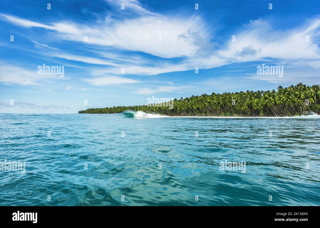 Wave breaking on the beach of a tropical island Stock Photo - Alamy