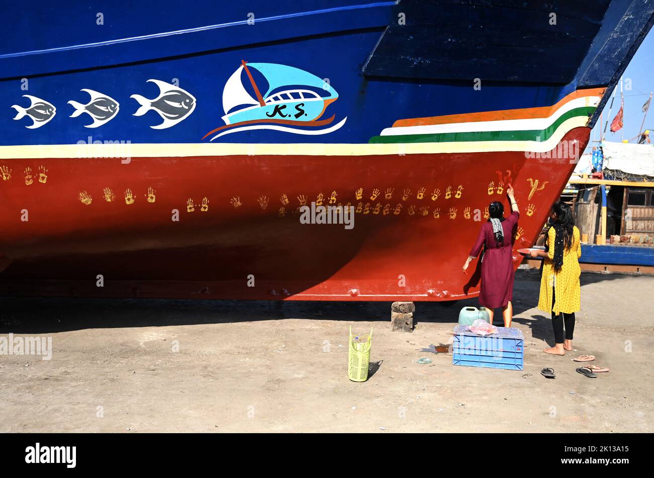Family of boat owner performs puja on new boat by making hand prints ... Family of boat owner performs puja on new boat by making hand prints ...
