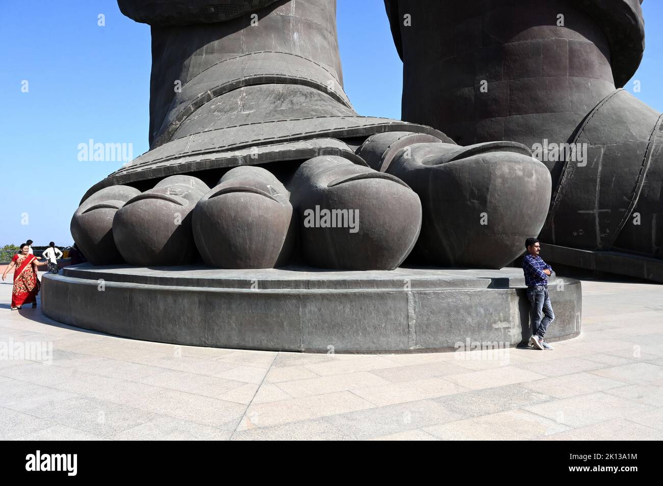 Visitors walking round a foot of The Statue of Unity, the world's ...