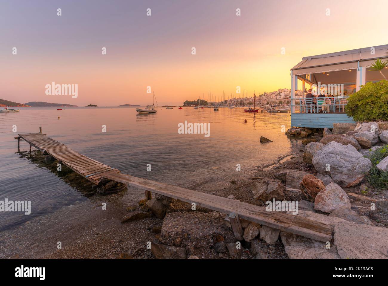 View of boats and restaurants in Skiathos Town at sunset, Skiathos ...