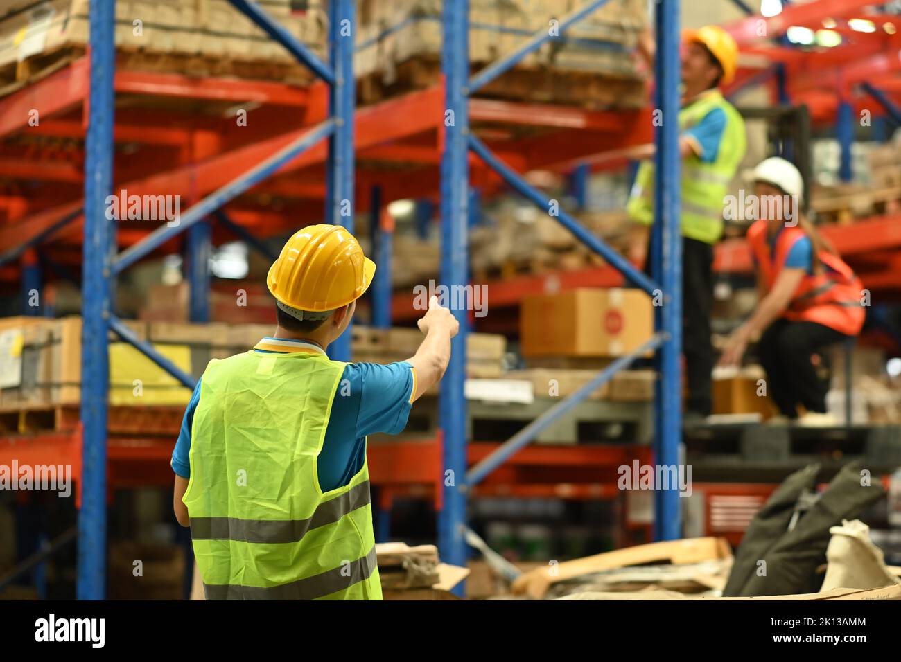 Back view of male manager wearing hardhat and reflective jacket ...