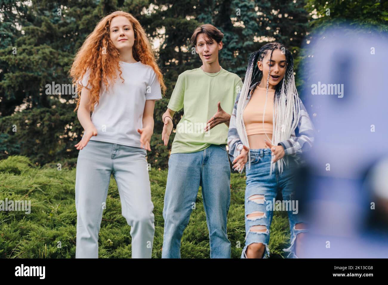 Three teenagers people using camera of smartphone recording video blog ...