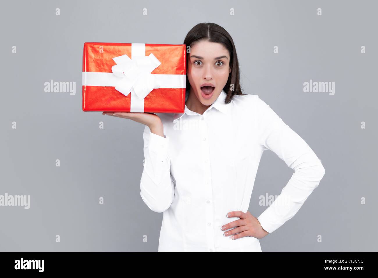 Attractive woman with present box posing with surprised face expression ...