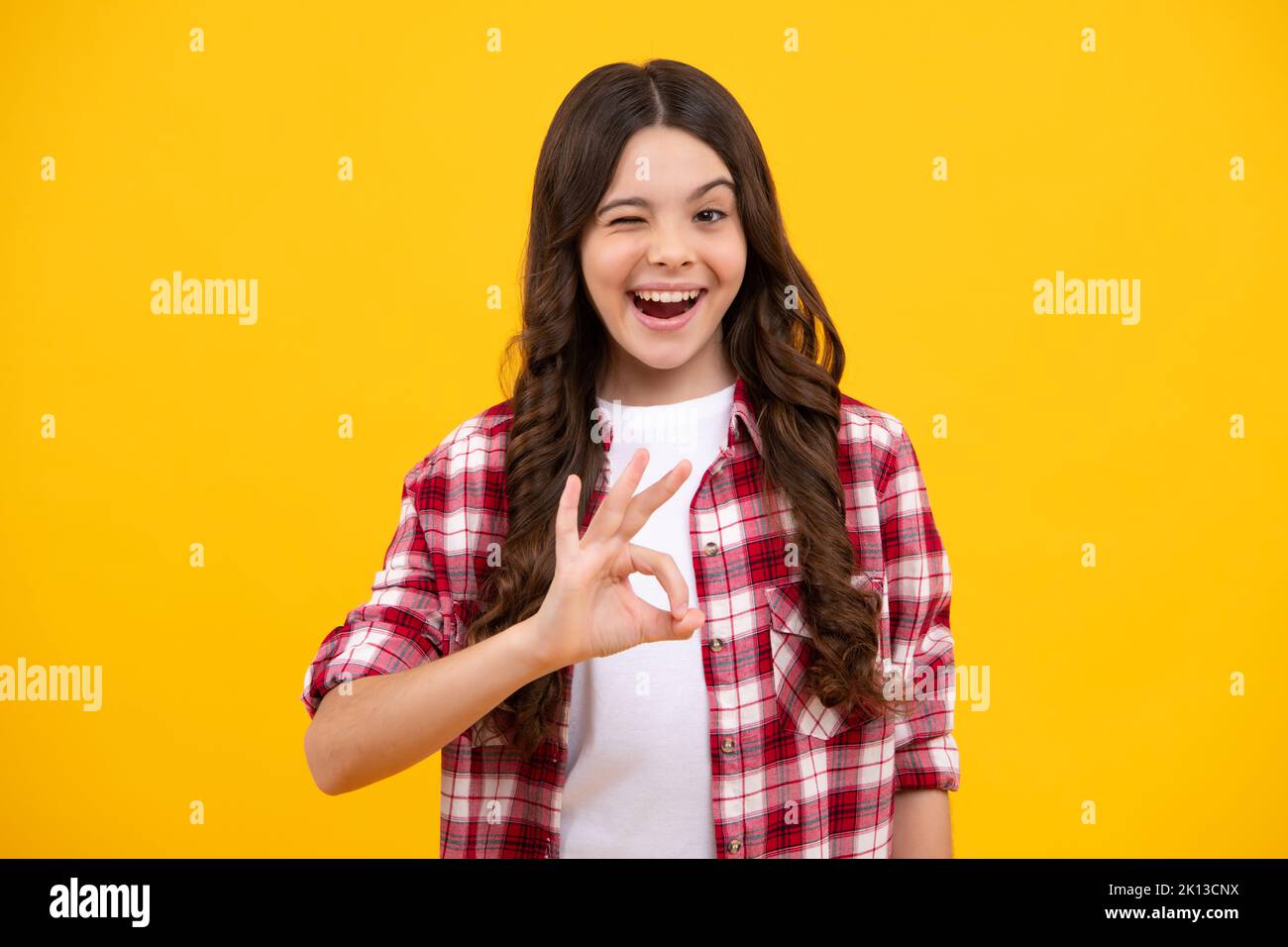 Okay. Funny teen child over yellow background doing ok gesture with ...