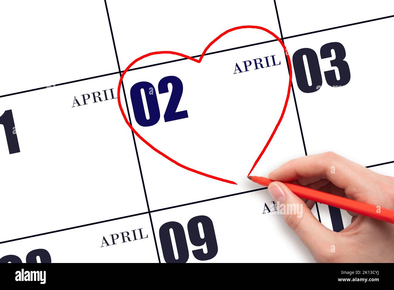 2nd day of April. A woman's hand drawing a red heart shape on the ...