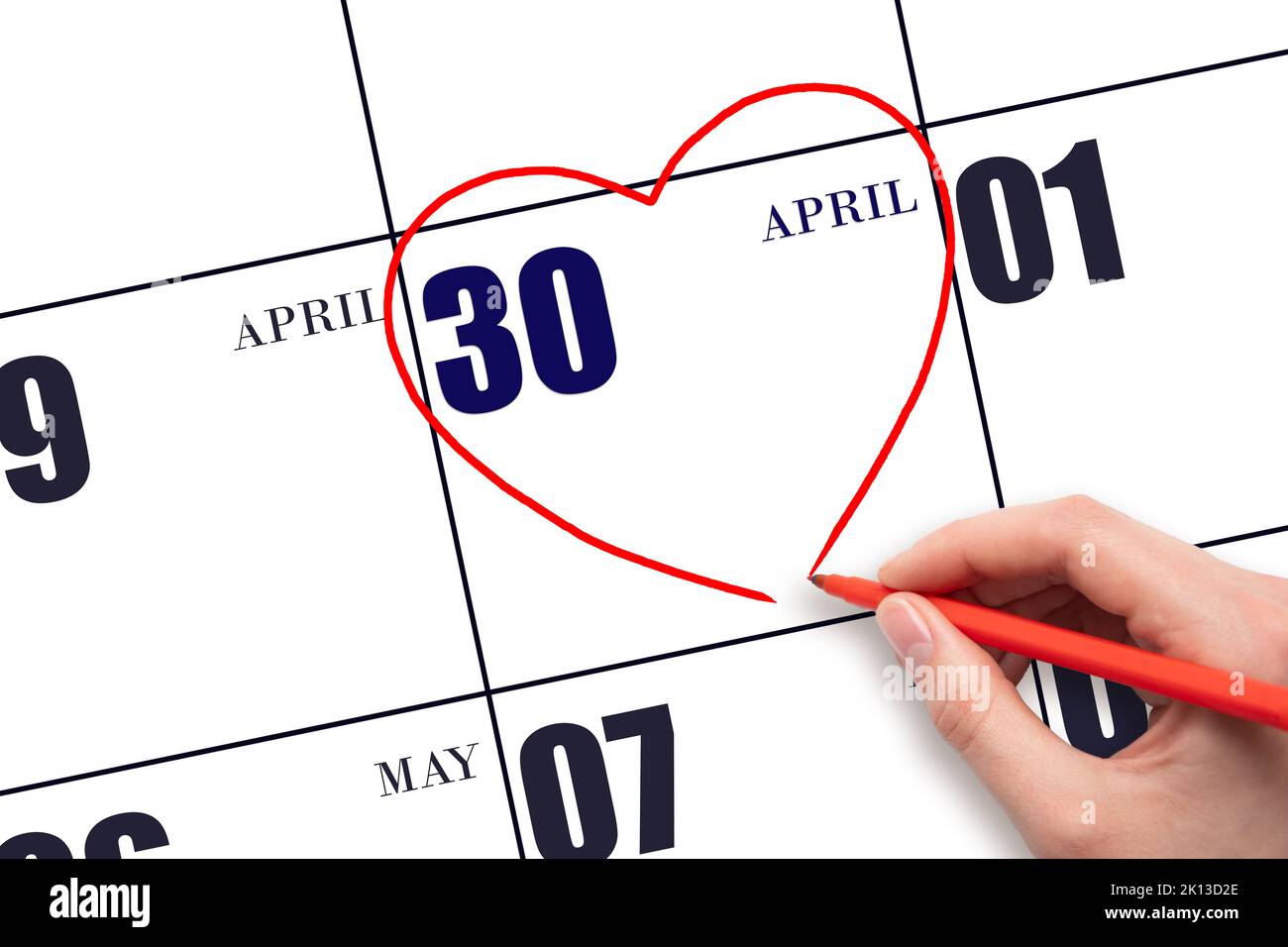 30th day of April. A woman's hand drawing a red heart shape on the ...