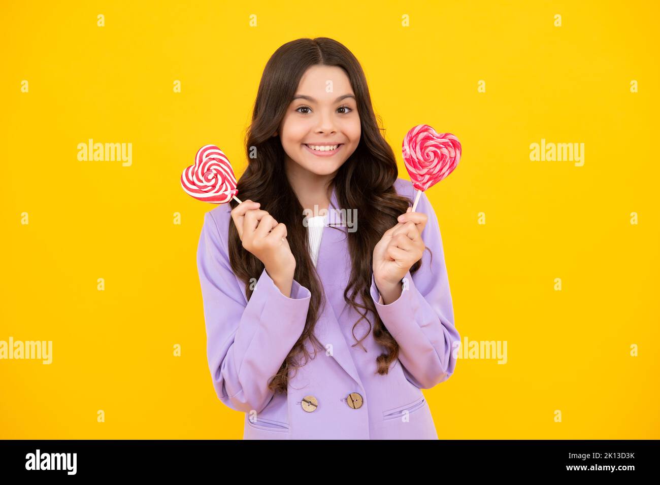 Cool teen child with lollipop over yellow isolated background. Sweet ...