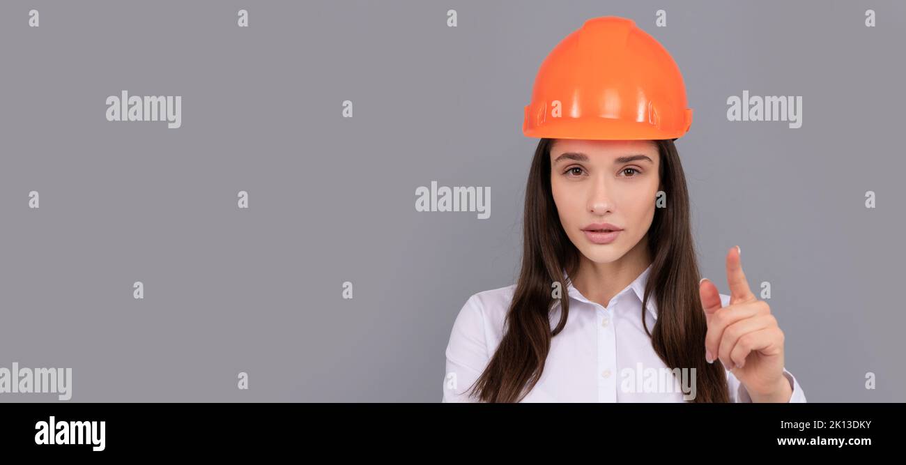 serious woman boss in protective helmet and white shirt pointing finger ...