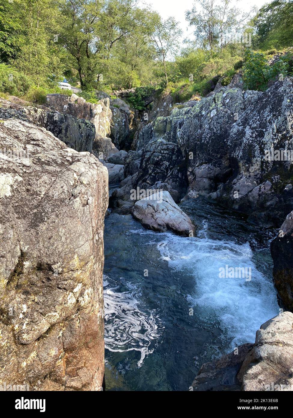 A River flowing between rocky cliffs with green trees Stock Photo - Alamy