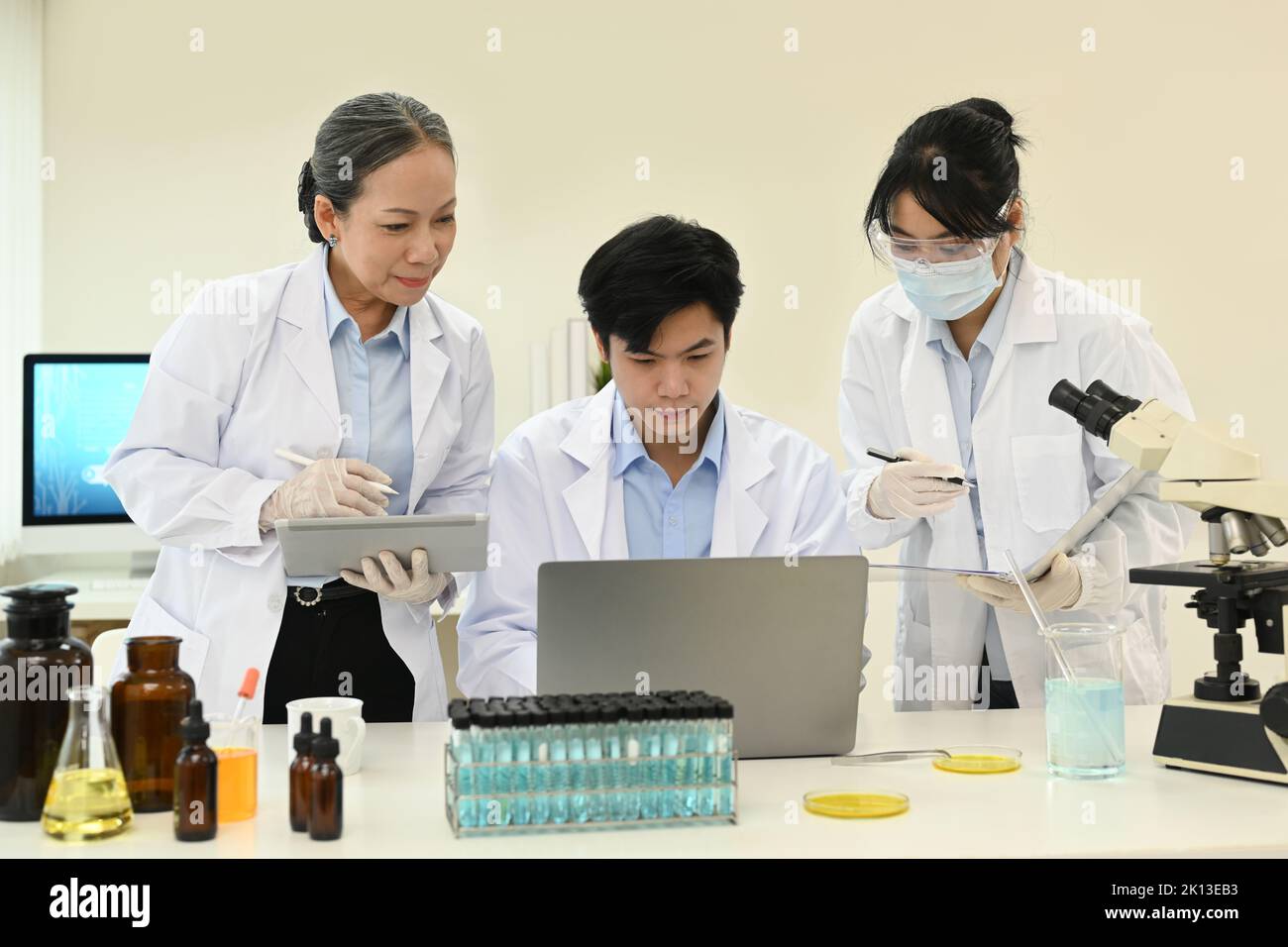 Senior woman scientist and young researcher collecting data and ...