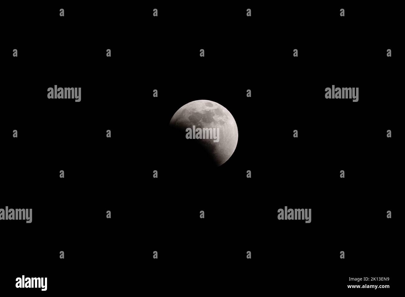 The lunar eclipse full crescent super moon rising against the dark sky ...