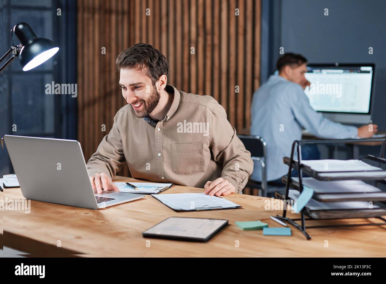 smiling business man working on a laptop in a night office Stock Photo ...