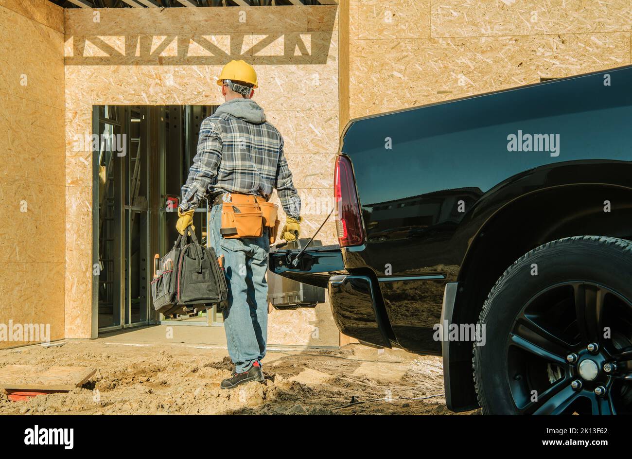 Construction Worker Carrying Tools From Pickup Truck to Building Site ...