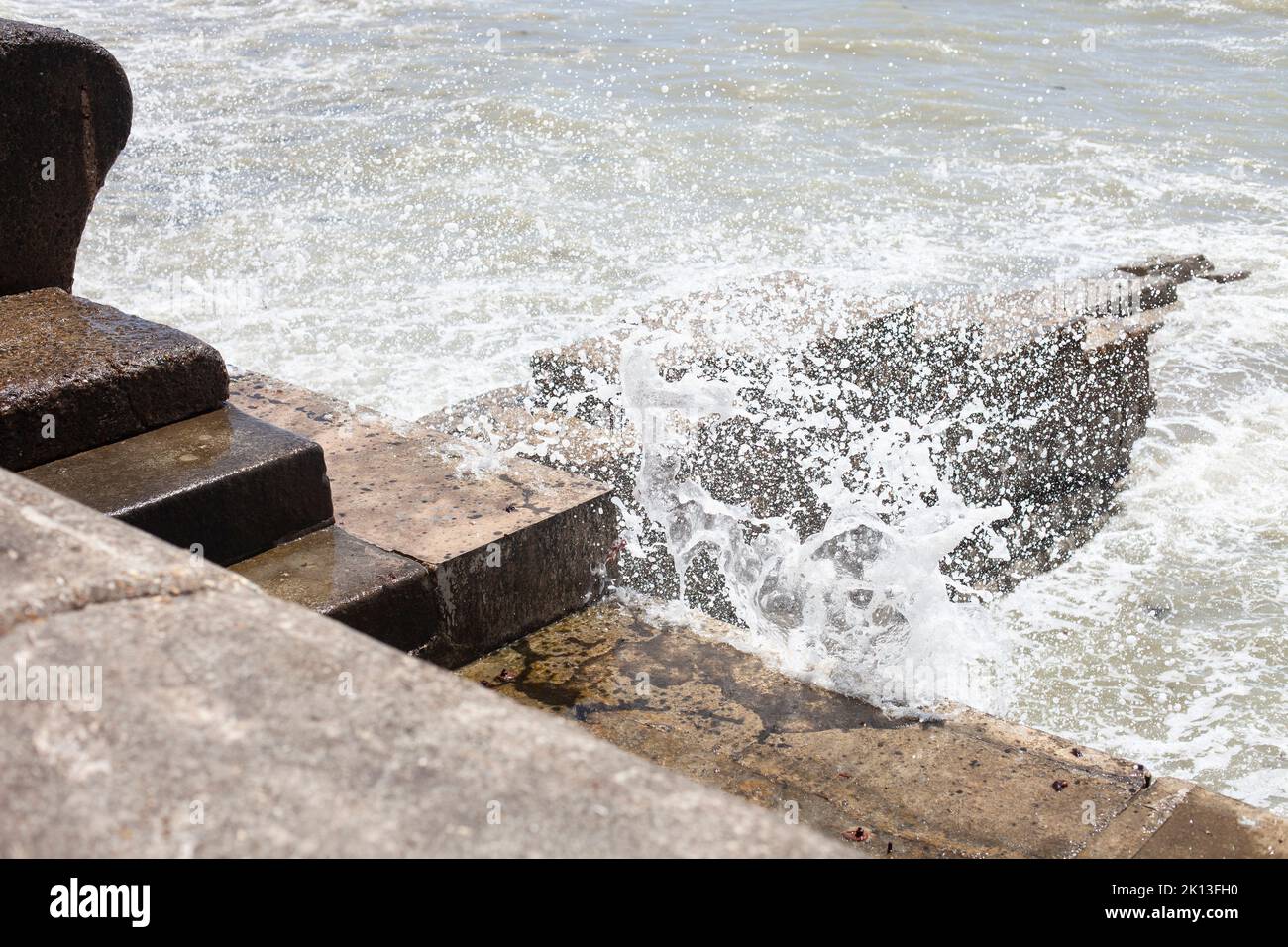 The stone edge of a fountain with water splashing Stock Photo - Alamy