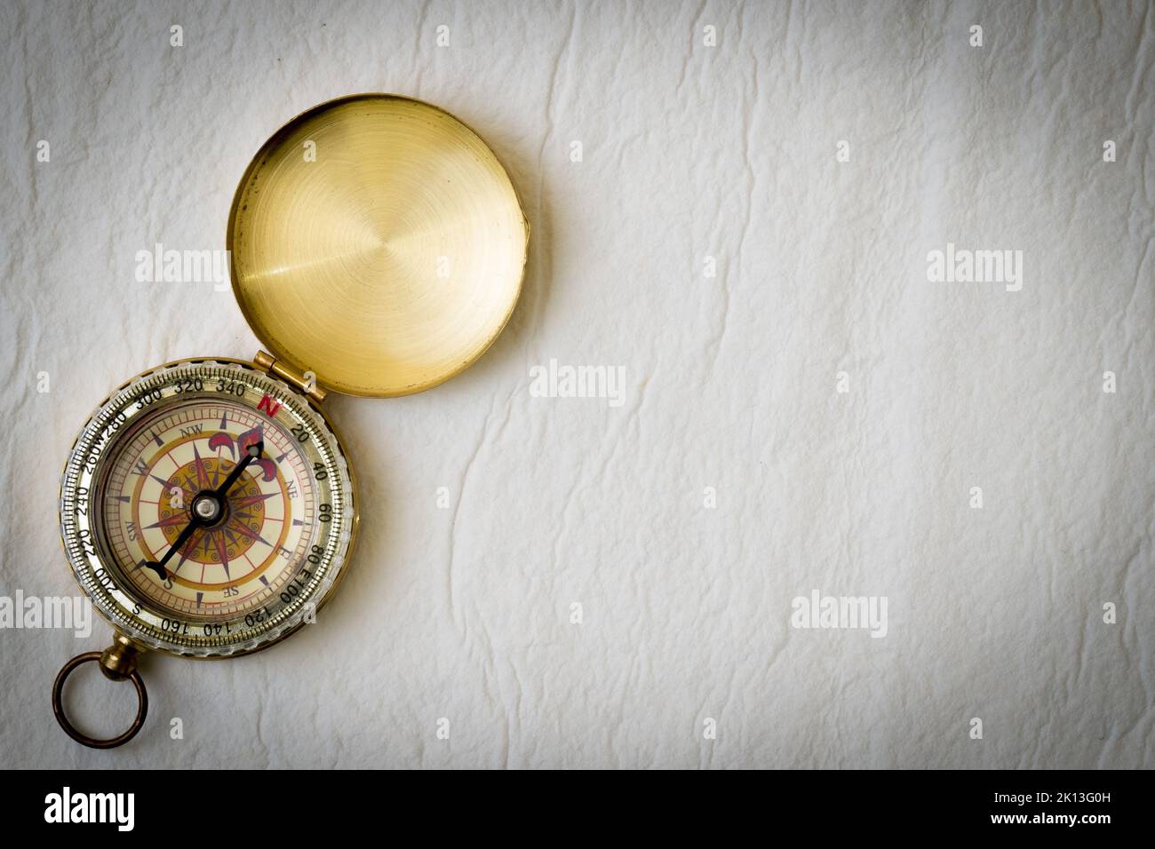 A vintage compass on white handmade paper Stock Photo - Alamy