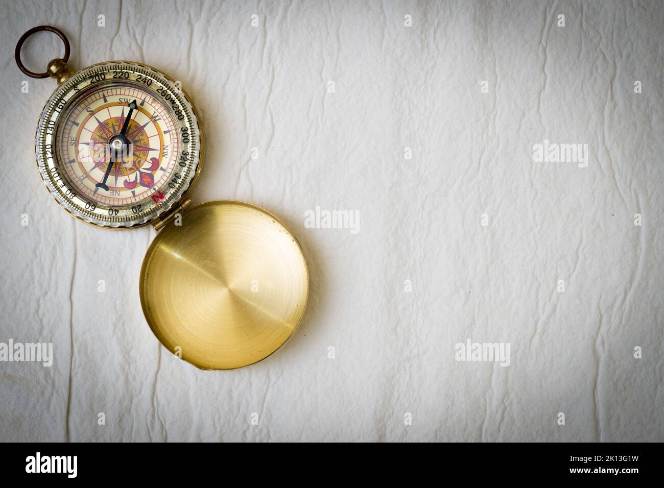 A vintage compass on white handmade paper Stock Photo - Alamy