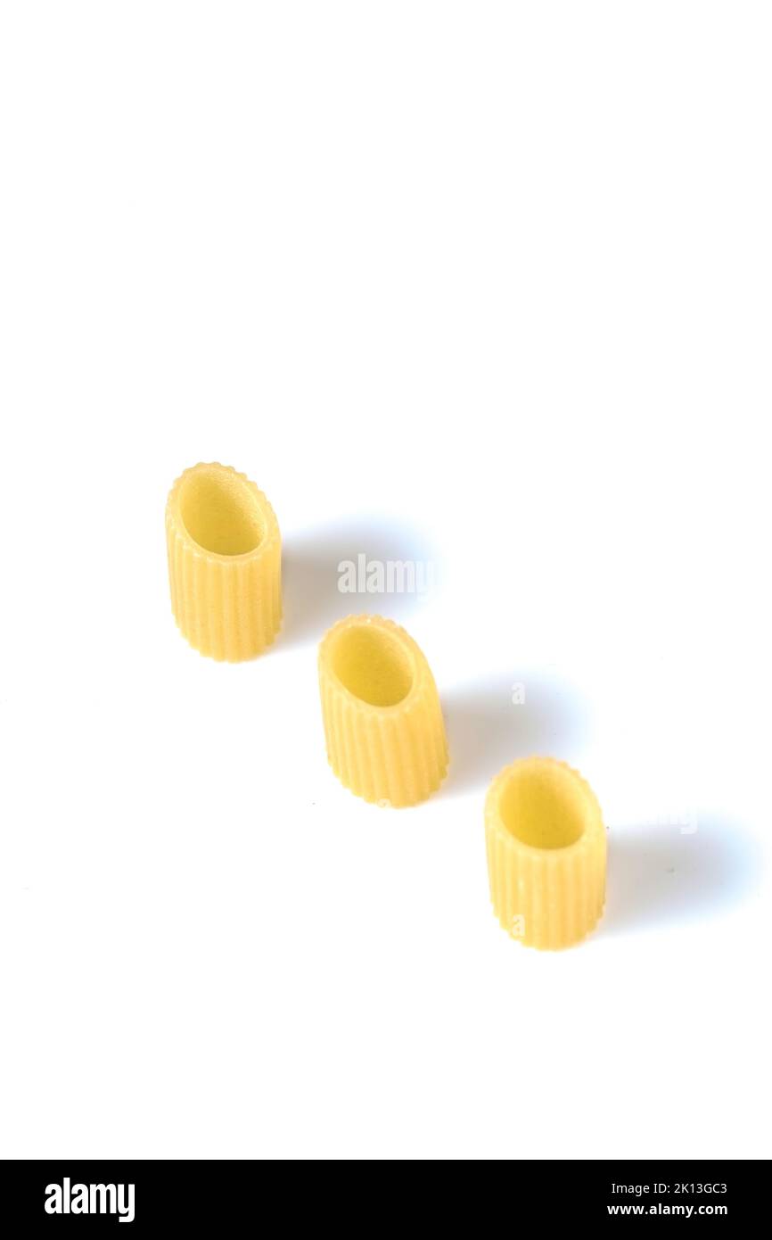 A vertical top closeup of three rigatoni pasta with white background ...