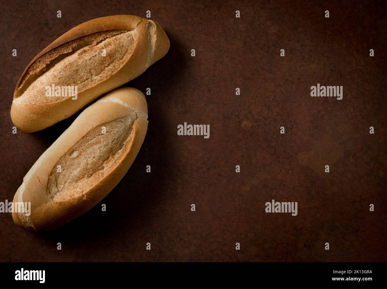 A top shot of bulk loaves of bread on the dark background Stock Photo ...