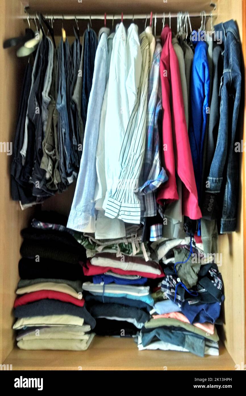 A wardrobe full of colorful hanged and folded clothes Stock Photo - Alamy
