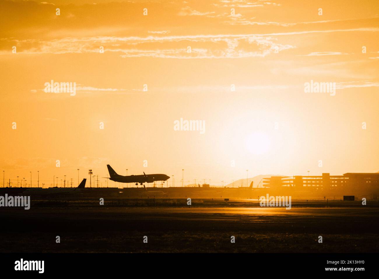 A commercial plane flying over the airport during sunset in Salt Lake ...