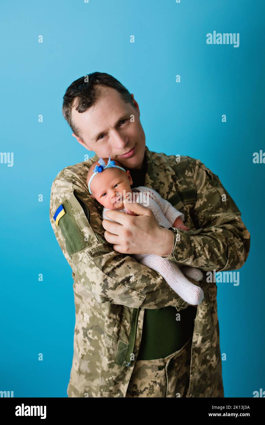 Ukrainian military man father with newborn baby girl on blue isolated ...