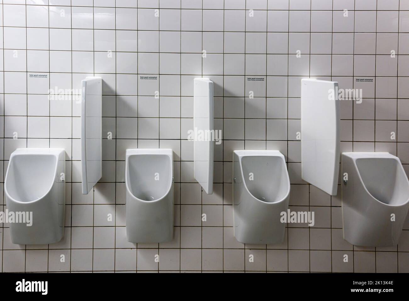 Row of urinals on a tiled wall, Schiphol Airport, Netherlands Stock ...