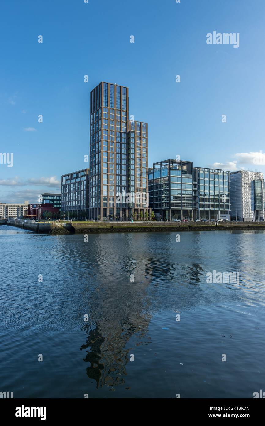 A vertical shot of a high-rise glass building and the river in the ...
