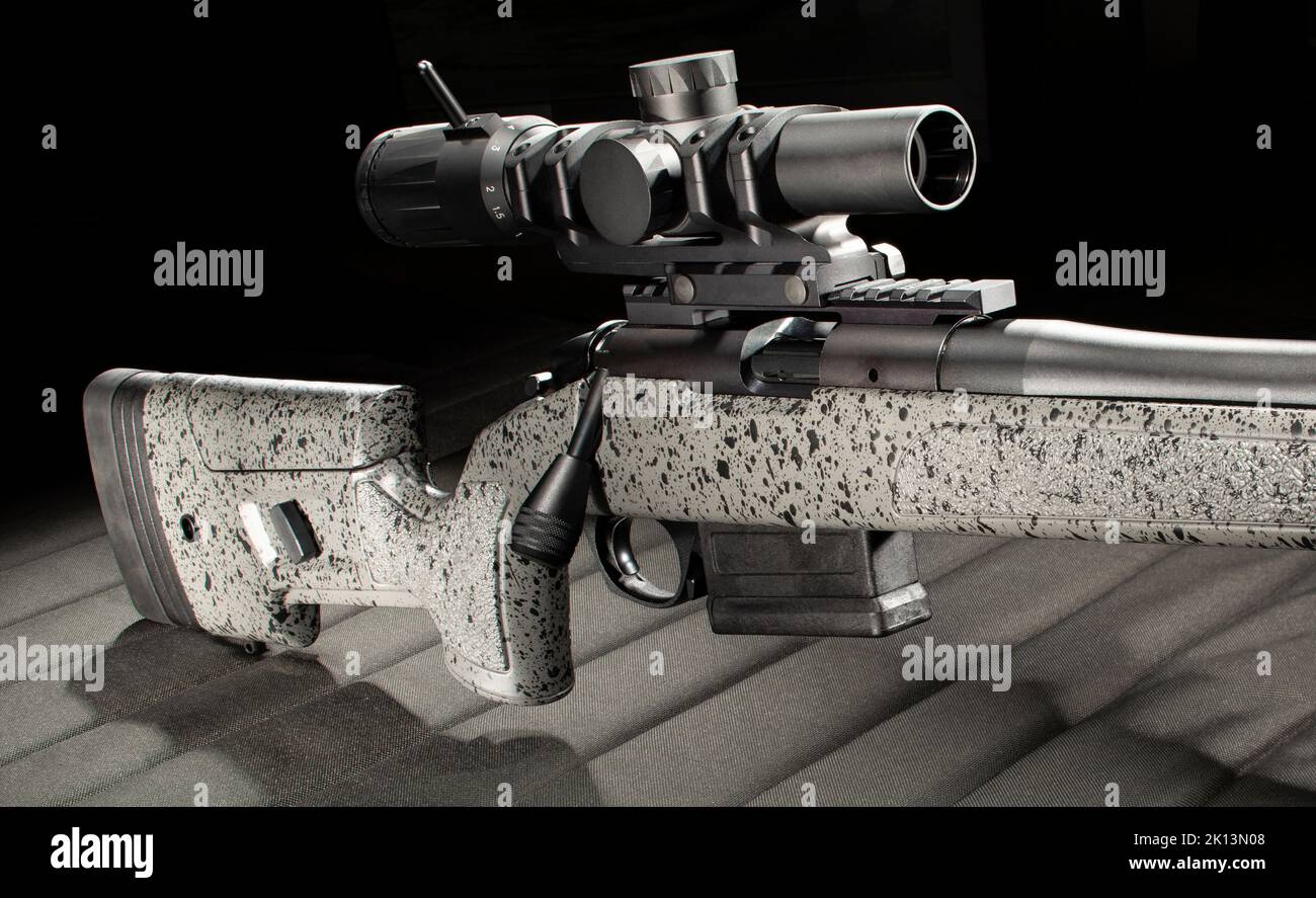 Bolt action rifle loaded with magazine and riflescope on a shooting mat ...