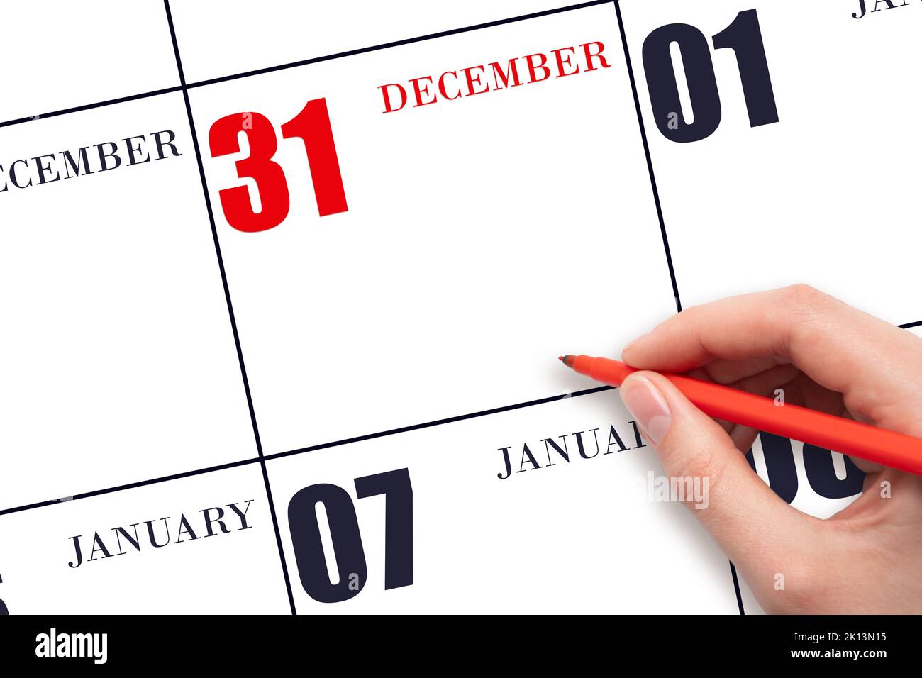 31st day of December. A hand holding a red pen and pointing on the ...