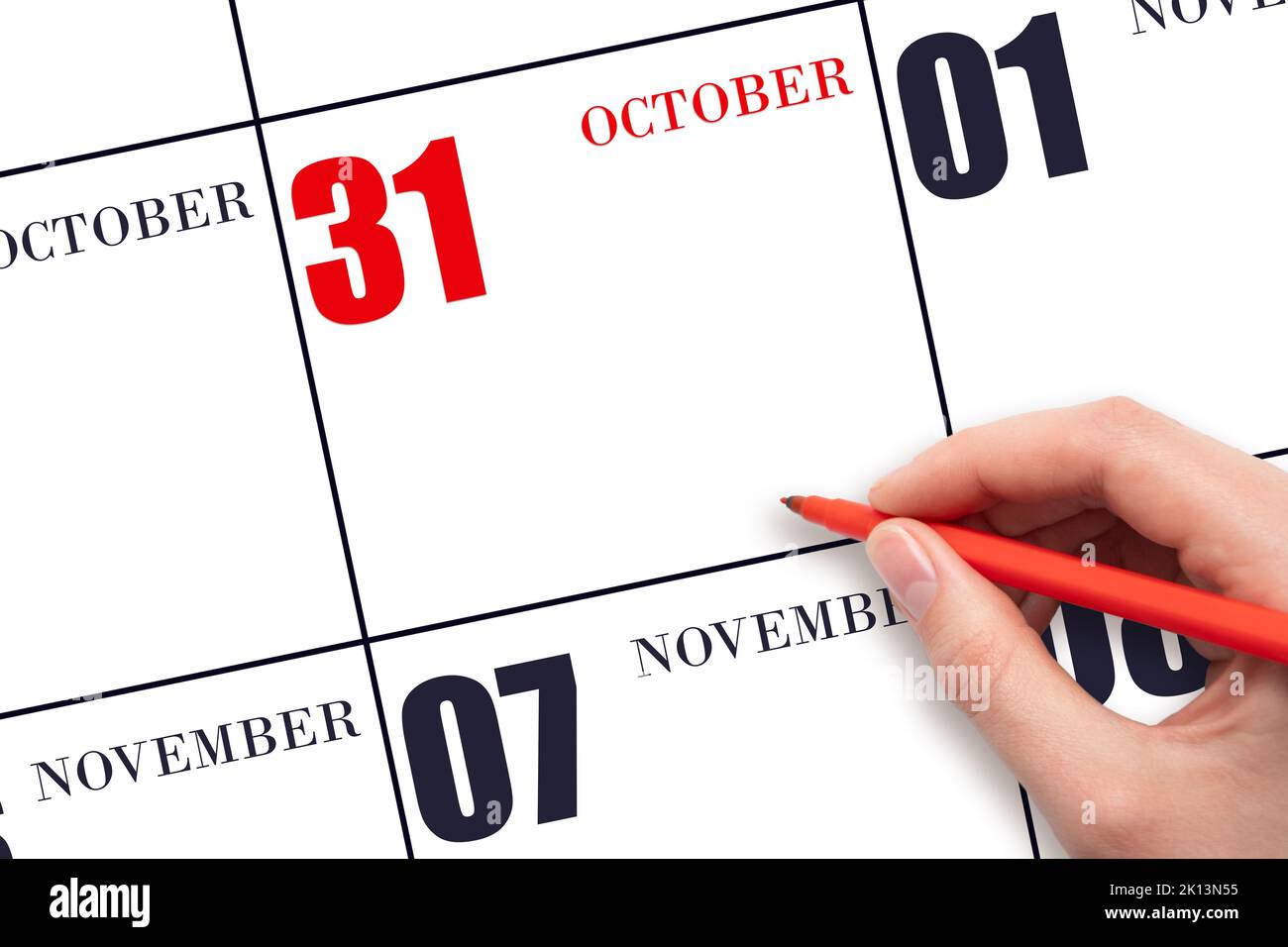 31st day of October. A hand holding a red pen and pointing on the ...