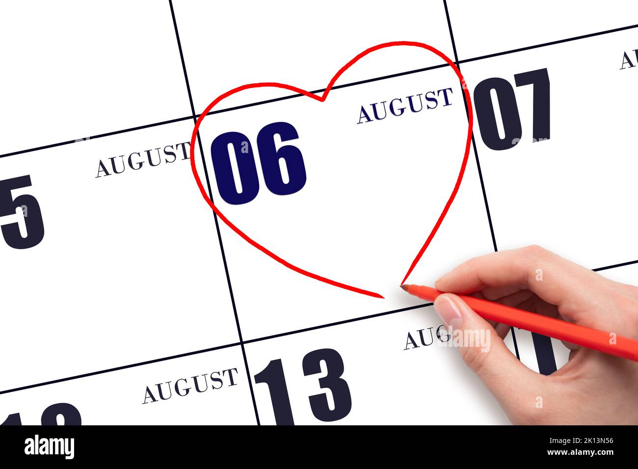 6th day of August. A woman's hand drawing a red heart shape on the ...