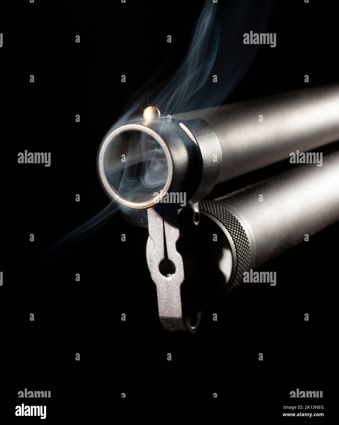 Smoke from the muzzle of a shotgun after the shot on a black background ...